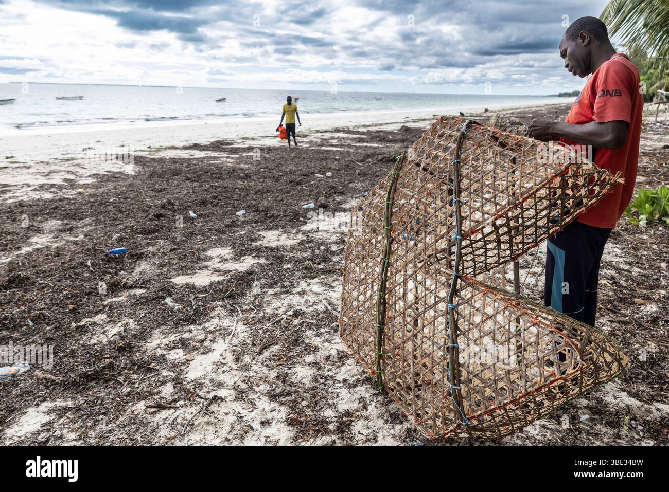 Tanzania, Zanzibar, a fisherman weighting a net with a stone These nets ...