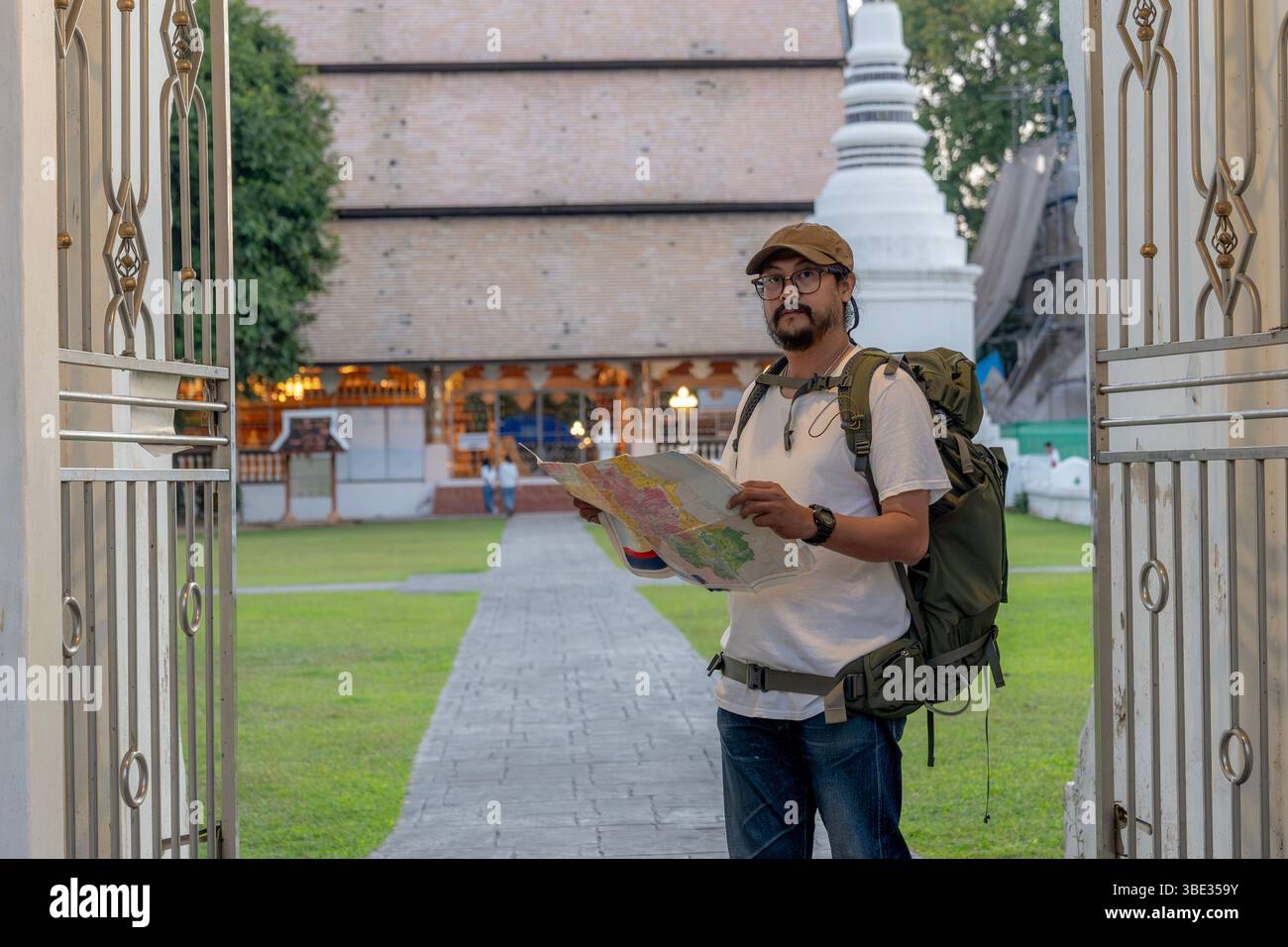 Asian male solo traveler exploring Thailand with a map in hand ...