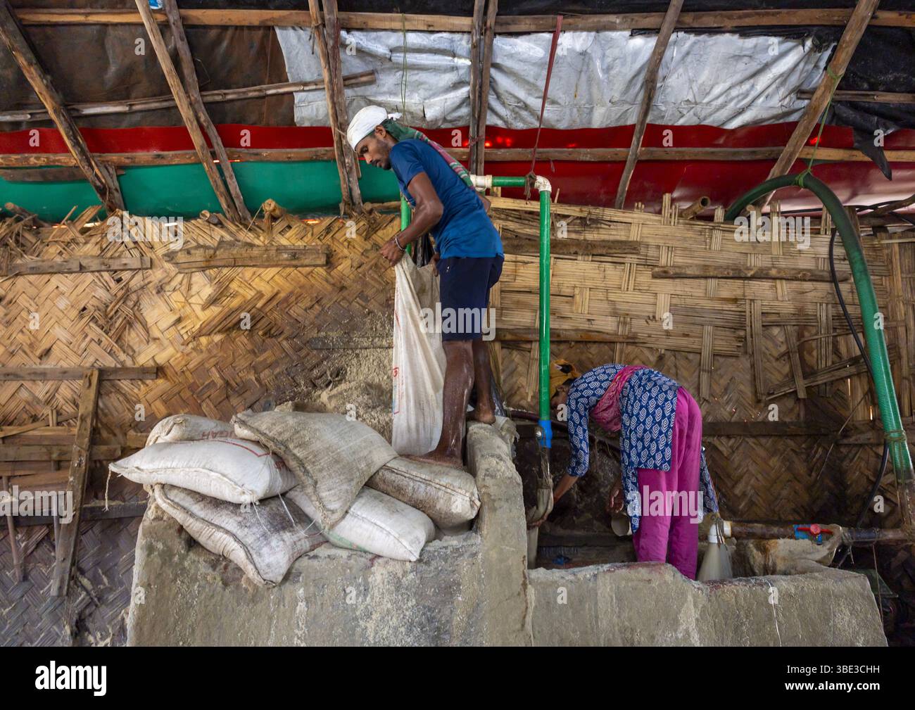 Bangladeshi workers packing salt in bags in a factory, Chittagong ...