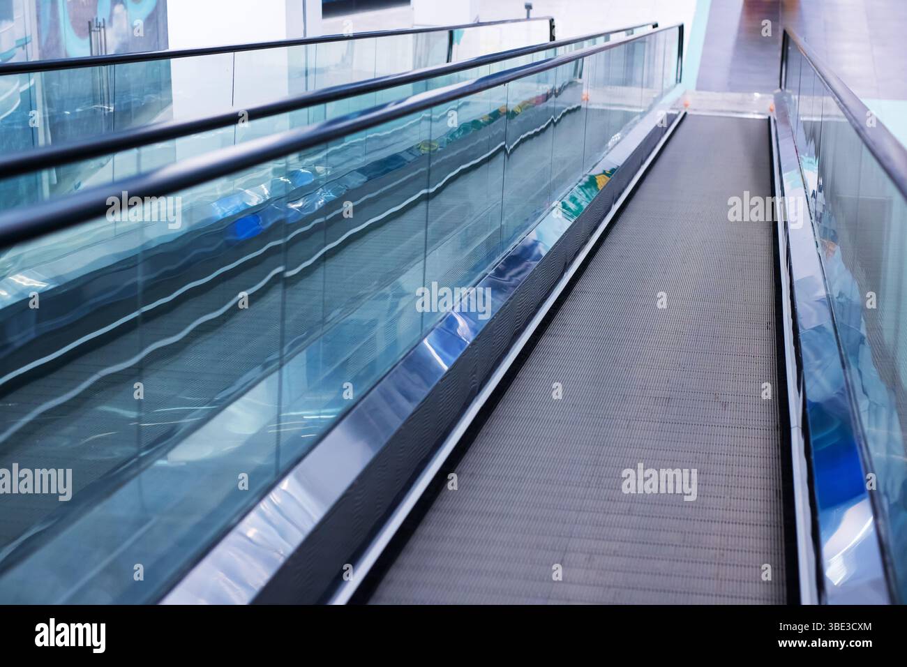There is a remarkably long escalator that features a sleek glass ...