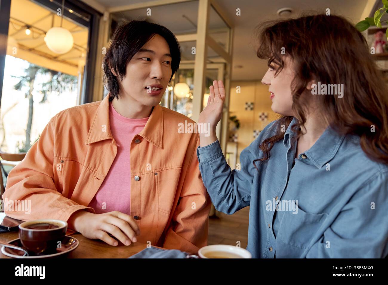 Two young friends engage in a lively conversation while enjoying their ...