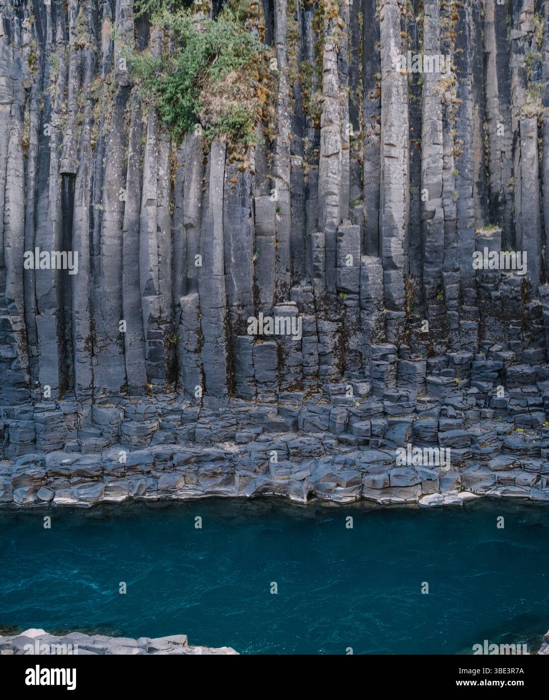 Basalt column wall above turquoise river in Studlagil Canyon, East ...