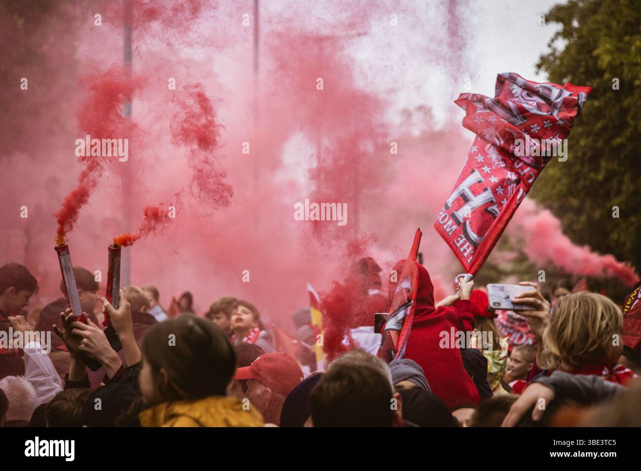 Crowds of Liverpool fans with red smoke bombs and flags on Queens Drive ...
