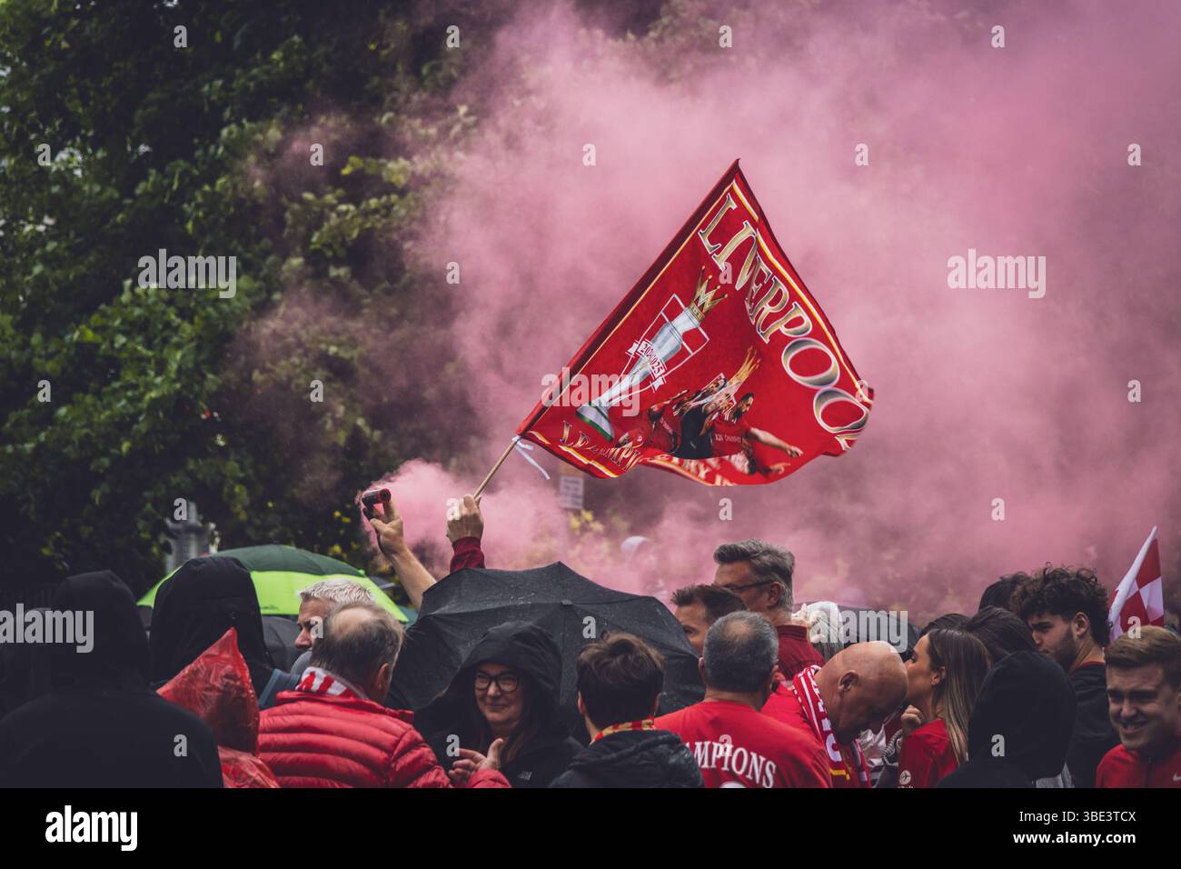 Crowds of Liverpool fans with red smoke bombs and flags on Queens Drive ...