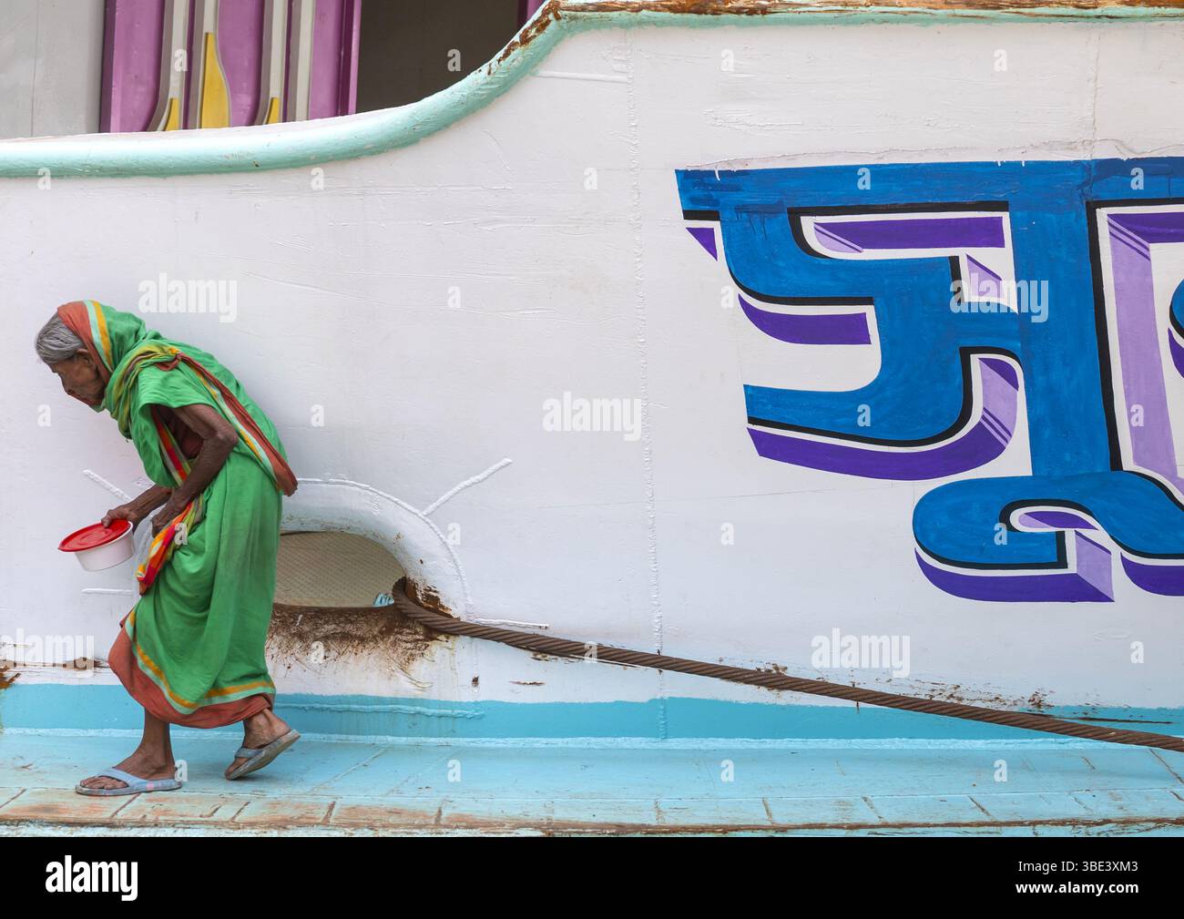 Old woman going inside an anchored ferry vessels at the dockyard, Dhaka ...