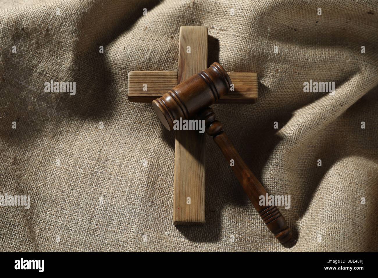Judge's gavel and wooden cross on burlap fabric, top view Stock Photo ...