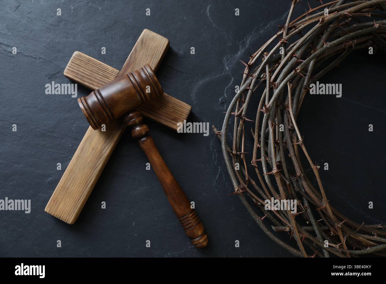 Judge's gavel, crown of thorns and wooden cross on black table, flat ...