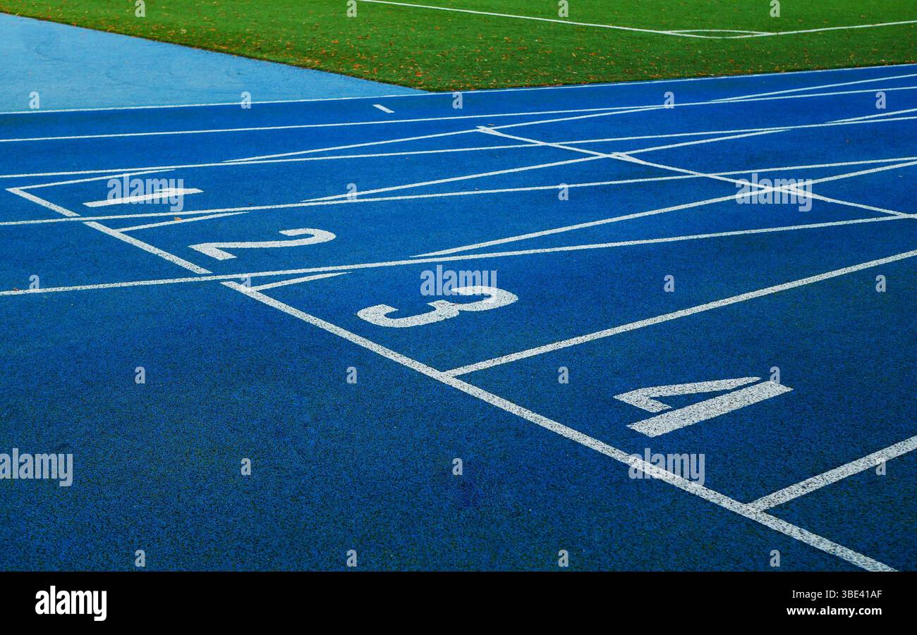 Blue running tracks with white lane markings and numbered start lines ...