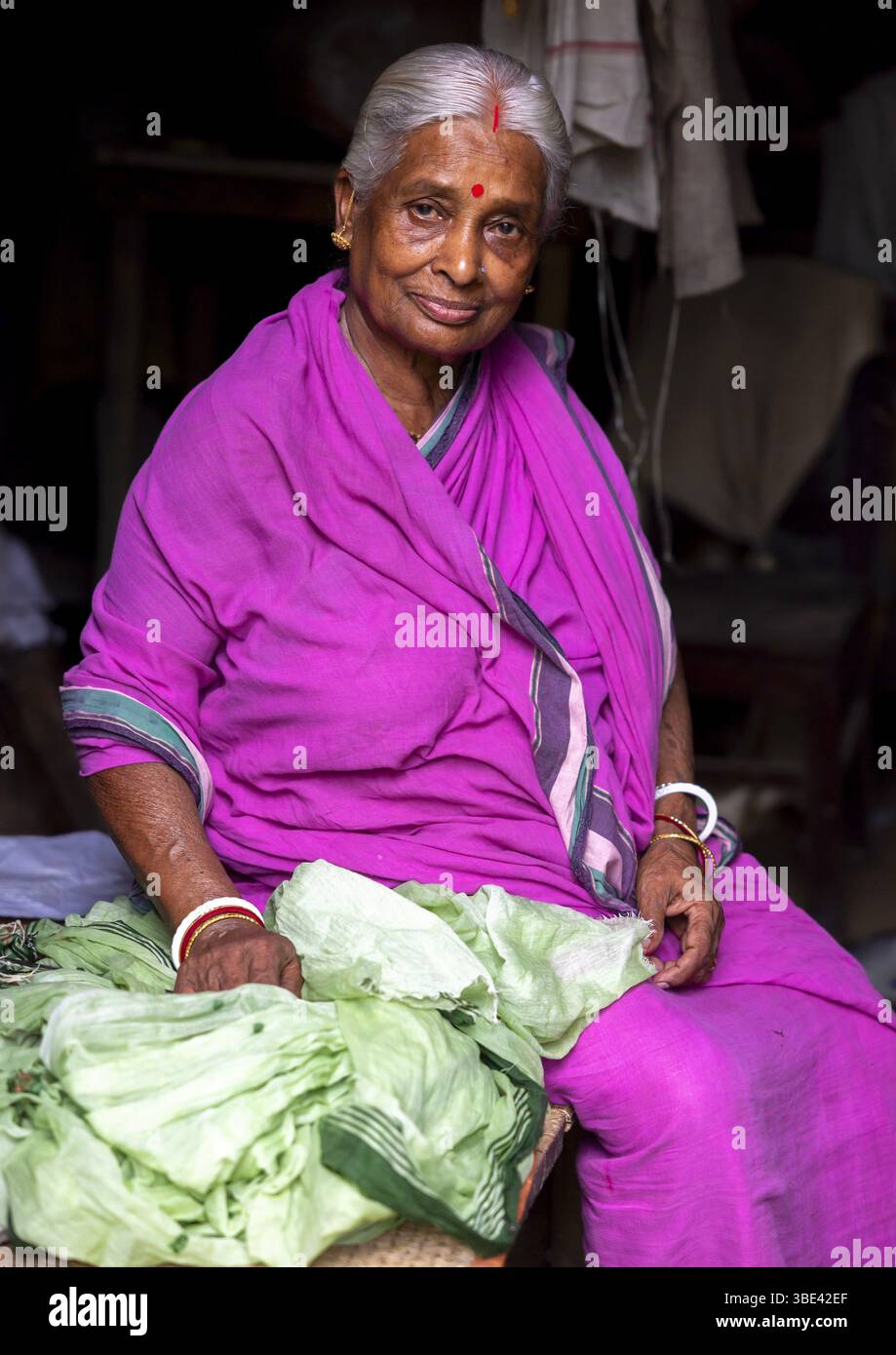 Portrait of an hindu bangladeshi old woman wearing a purple saree ...