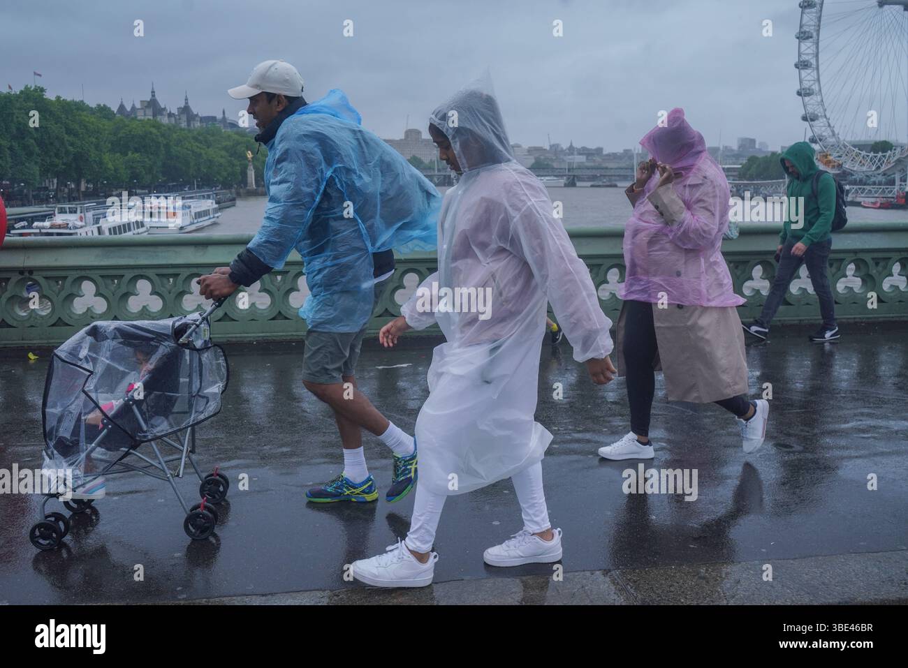 London, UK. 27 May 2025. Pedestrians wearing rain ponchos on ...