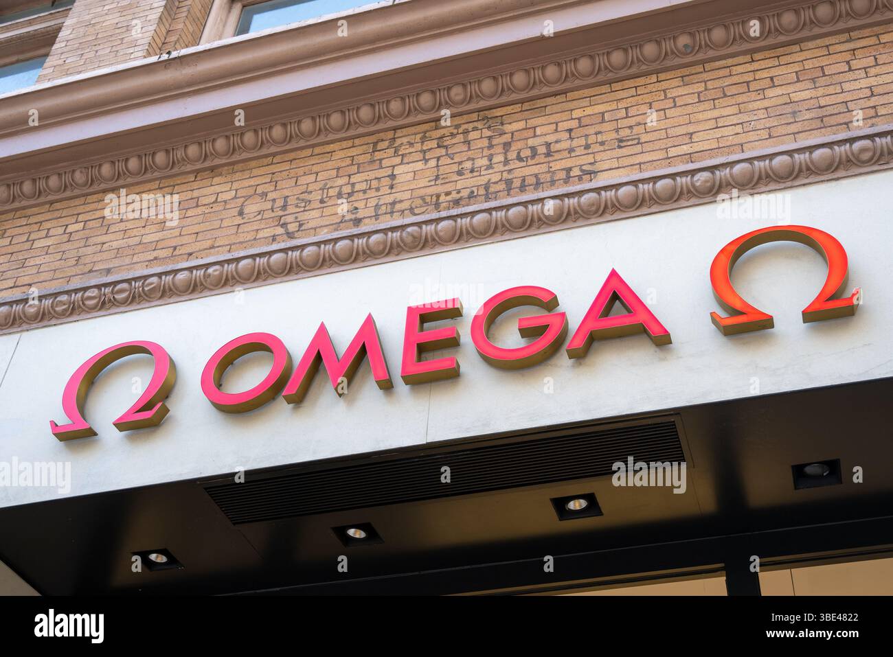 Omega watch boutique storefront with red logo on brick building facade ...