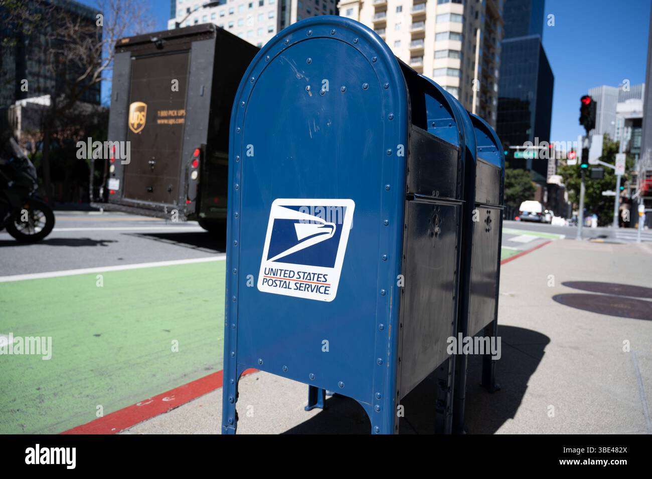 United States Postal Service mailbox on a busy street with a UPS truck ...