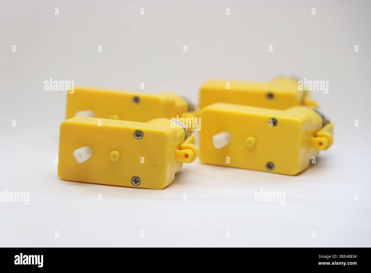 Plastic geared yellow dc motor with single shaft on a white background ...