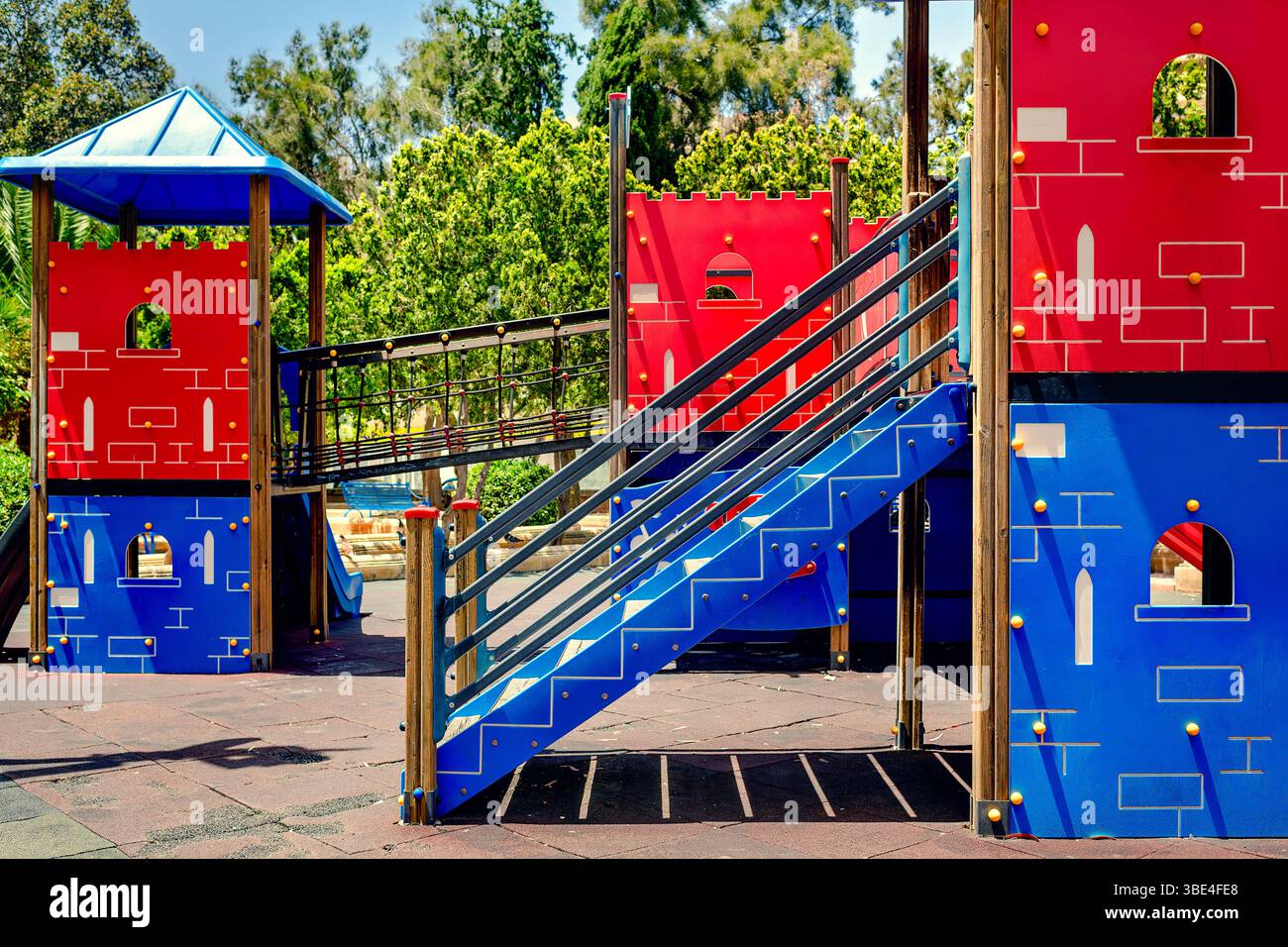 Bright and colorful children’s playground with castle-themed structures ...