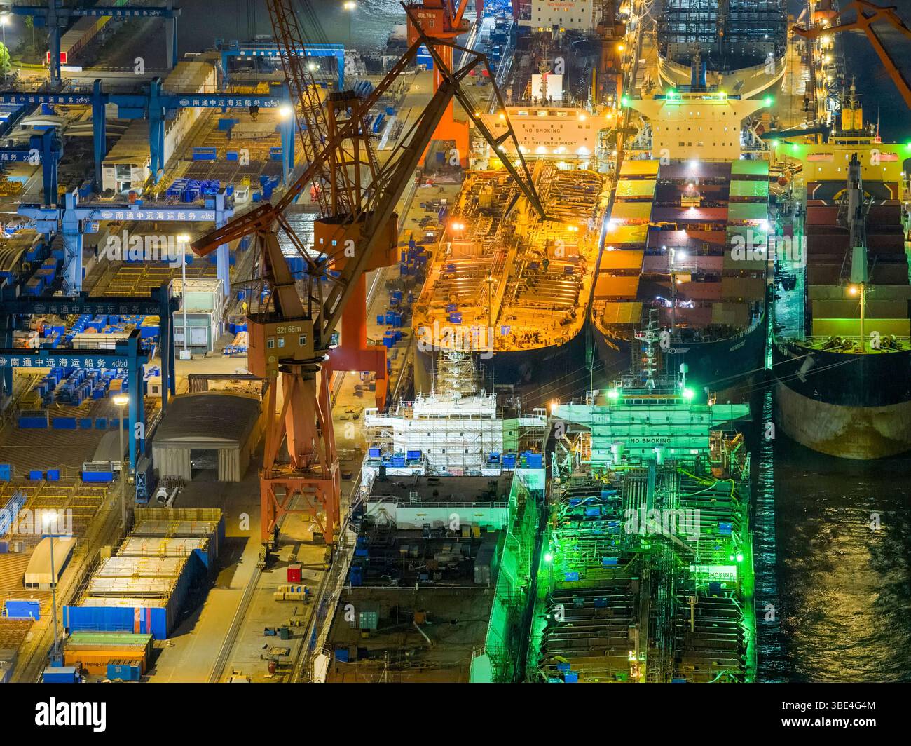 A night view of a shipyard where several ships are under construction ...