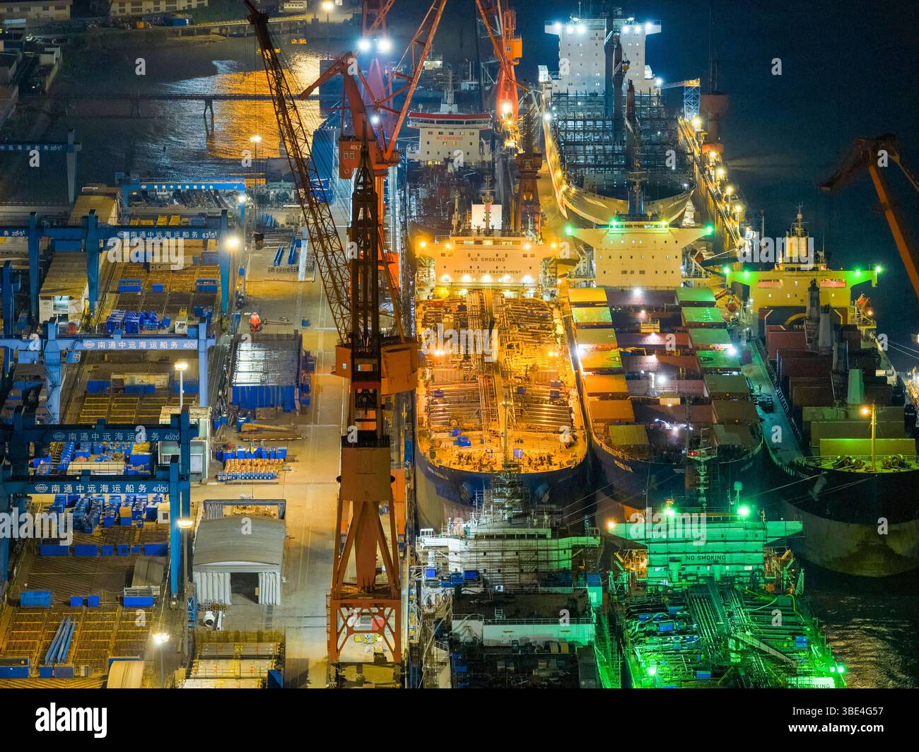 A night view of a shipyard where several ships are under construction ...