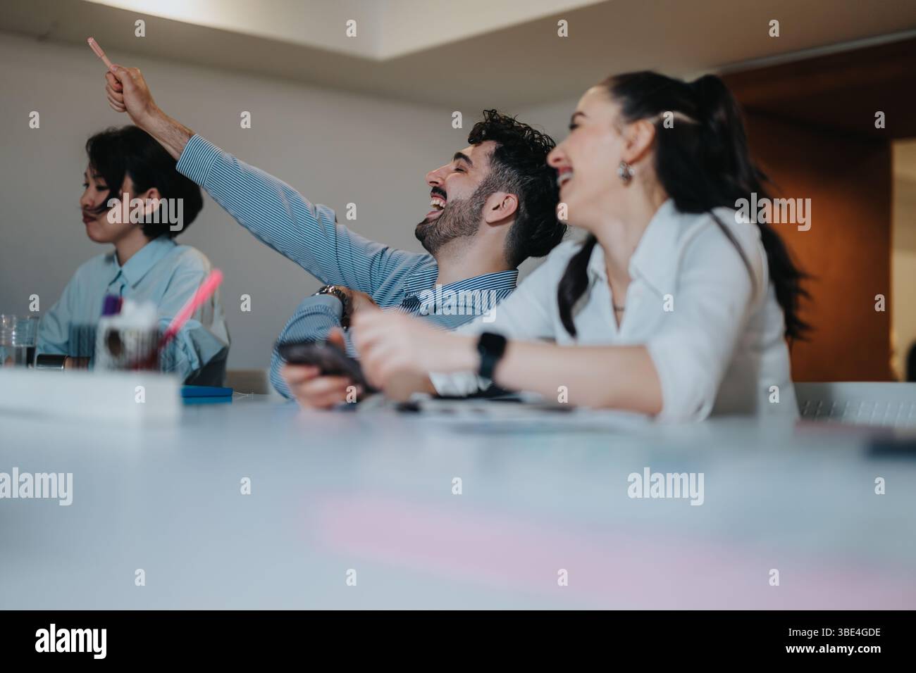 Team members enjoying a moment of laughter in a bright conference room ...