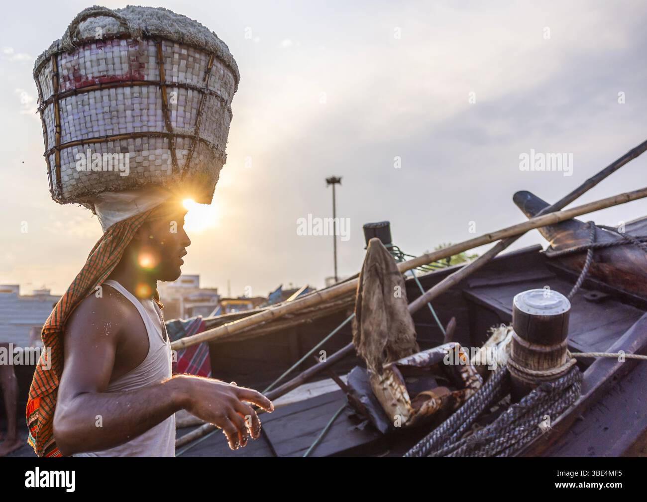 Bangladeshi man weighing basket with salt at a factory, Chittagong ...