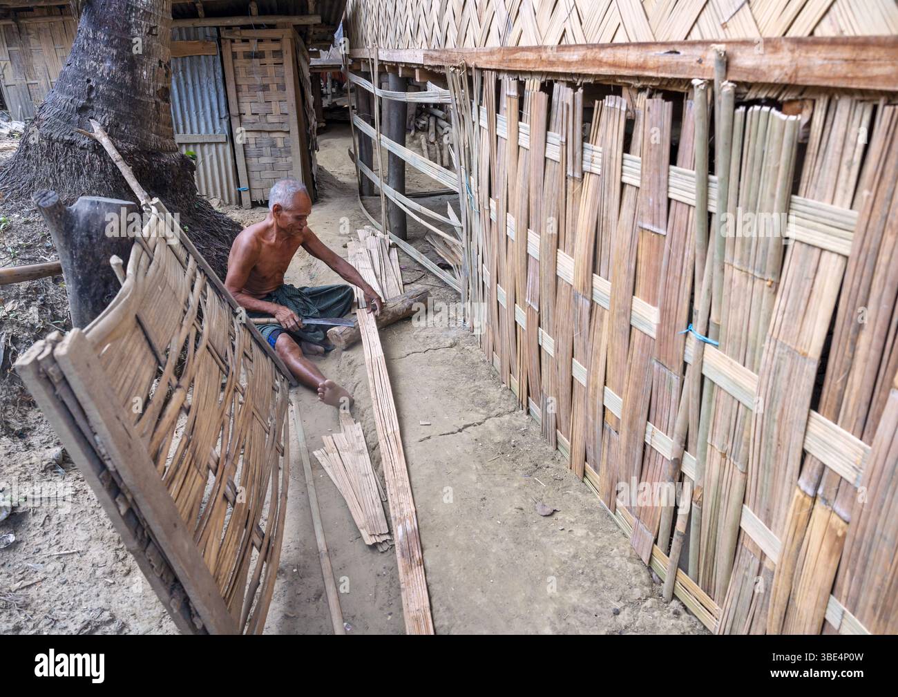 Marma ethnic group people man cutting bamboos to build a house ...