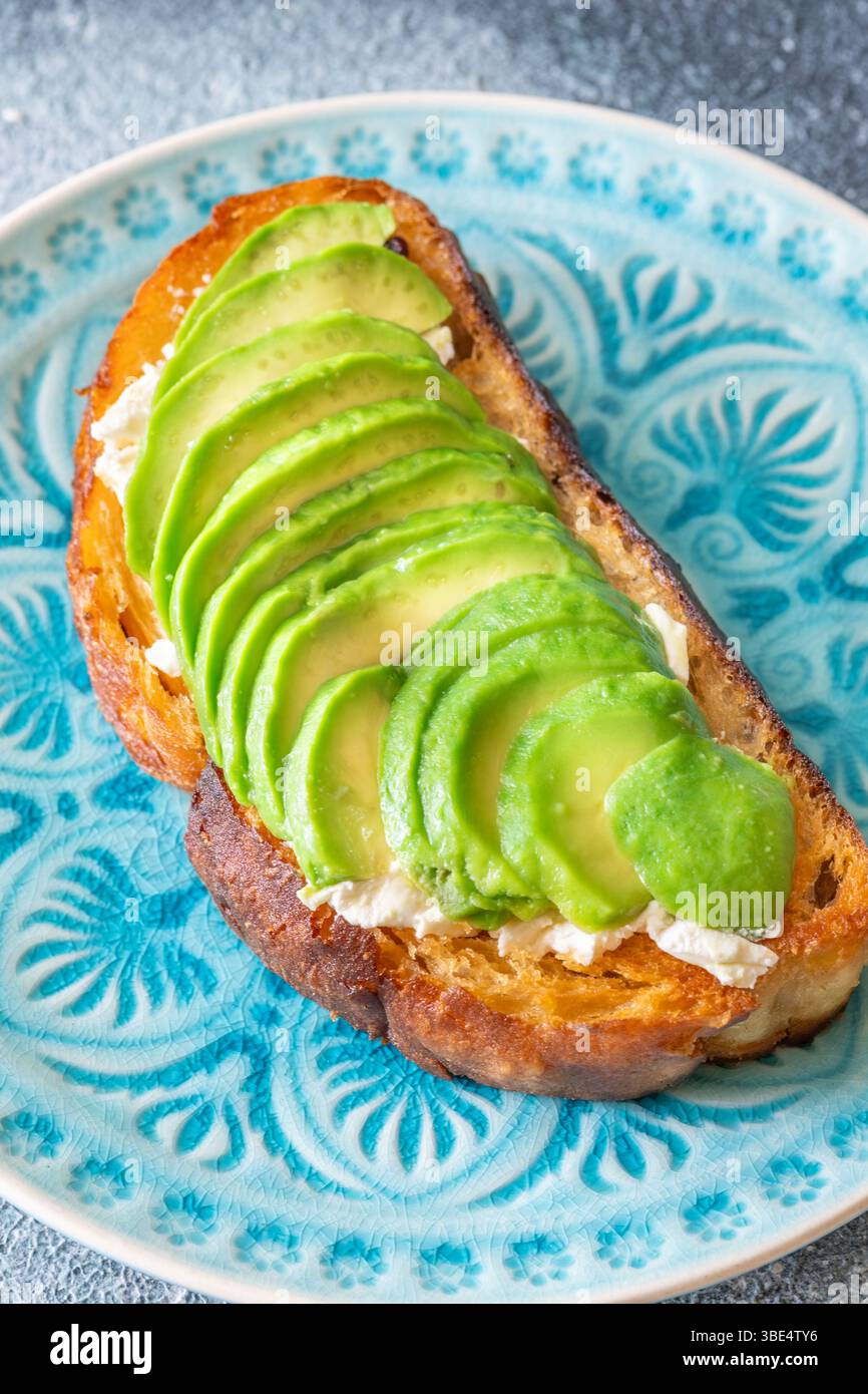 Bright avocado rests on creamy labneh, textures contrast beautifully on ...