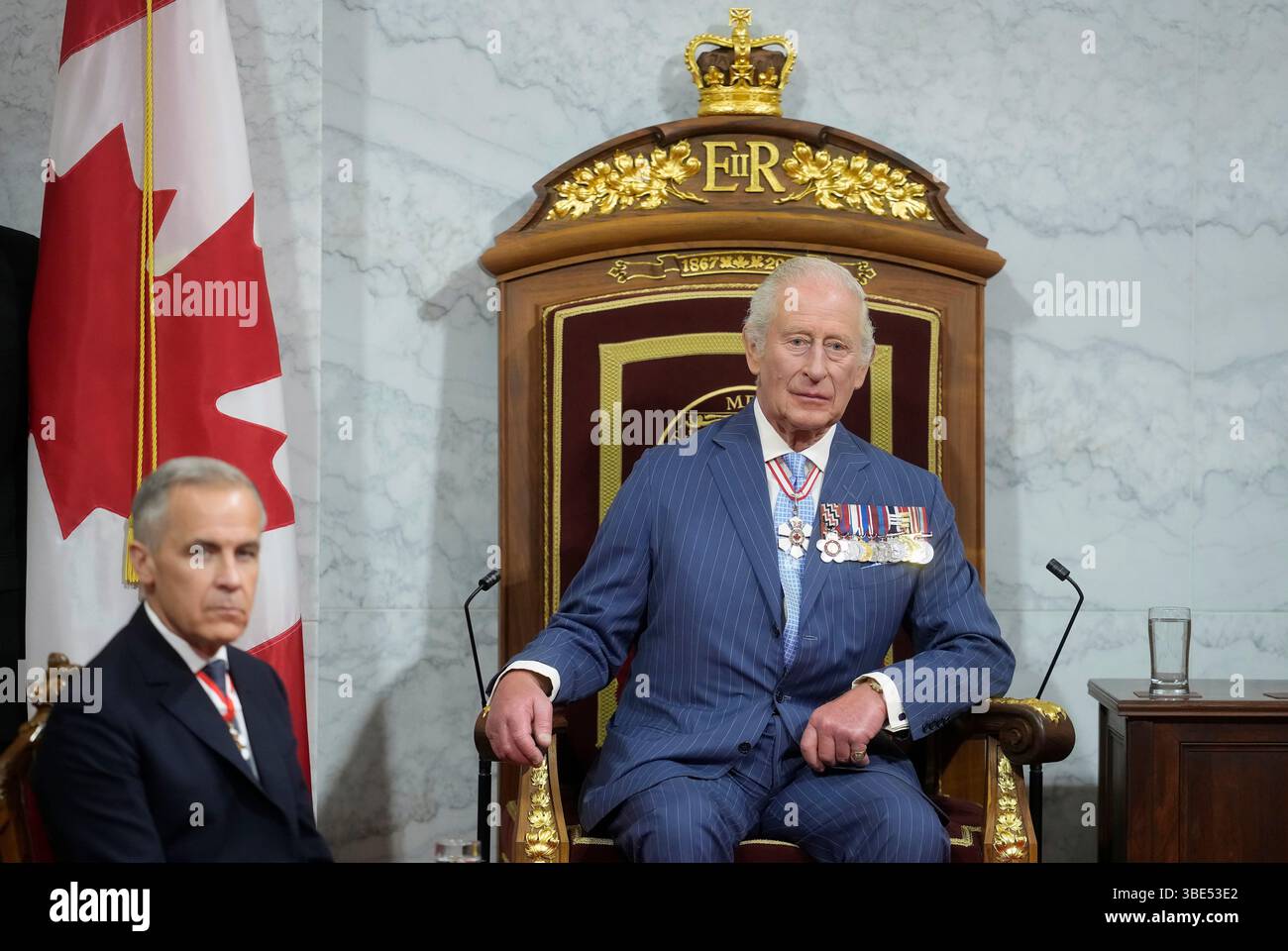Canada Prime Minister Mark Carney, left, and King Charles looks on ahead of the King delivering ...