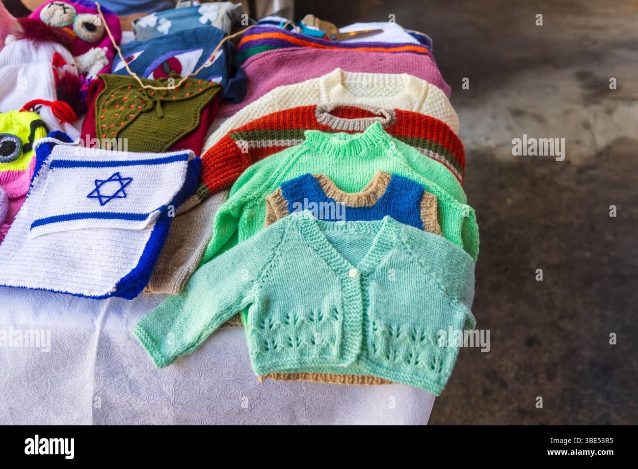An outdoor market stall displays an array of colorful, hand-knitted ...