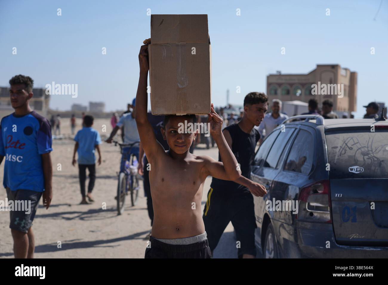 Palestinians carry boxes containing food and humanitarian aid packages ...