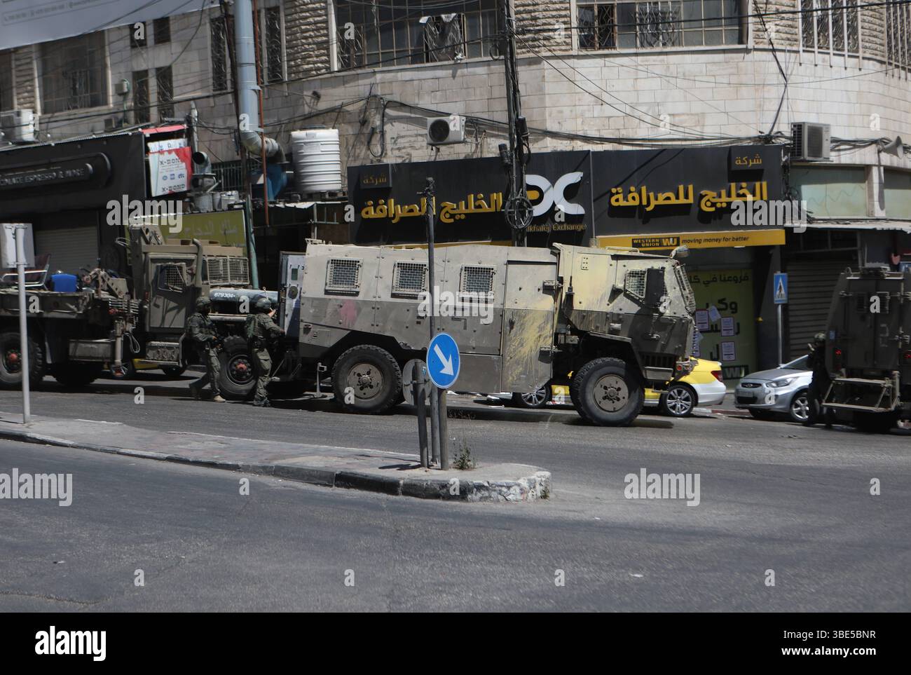Israeli toops storm a currency exchange shop next to signs warning ...