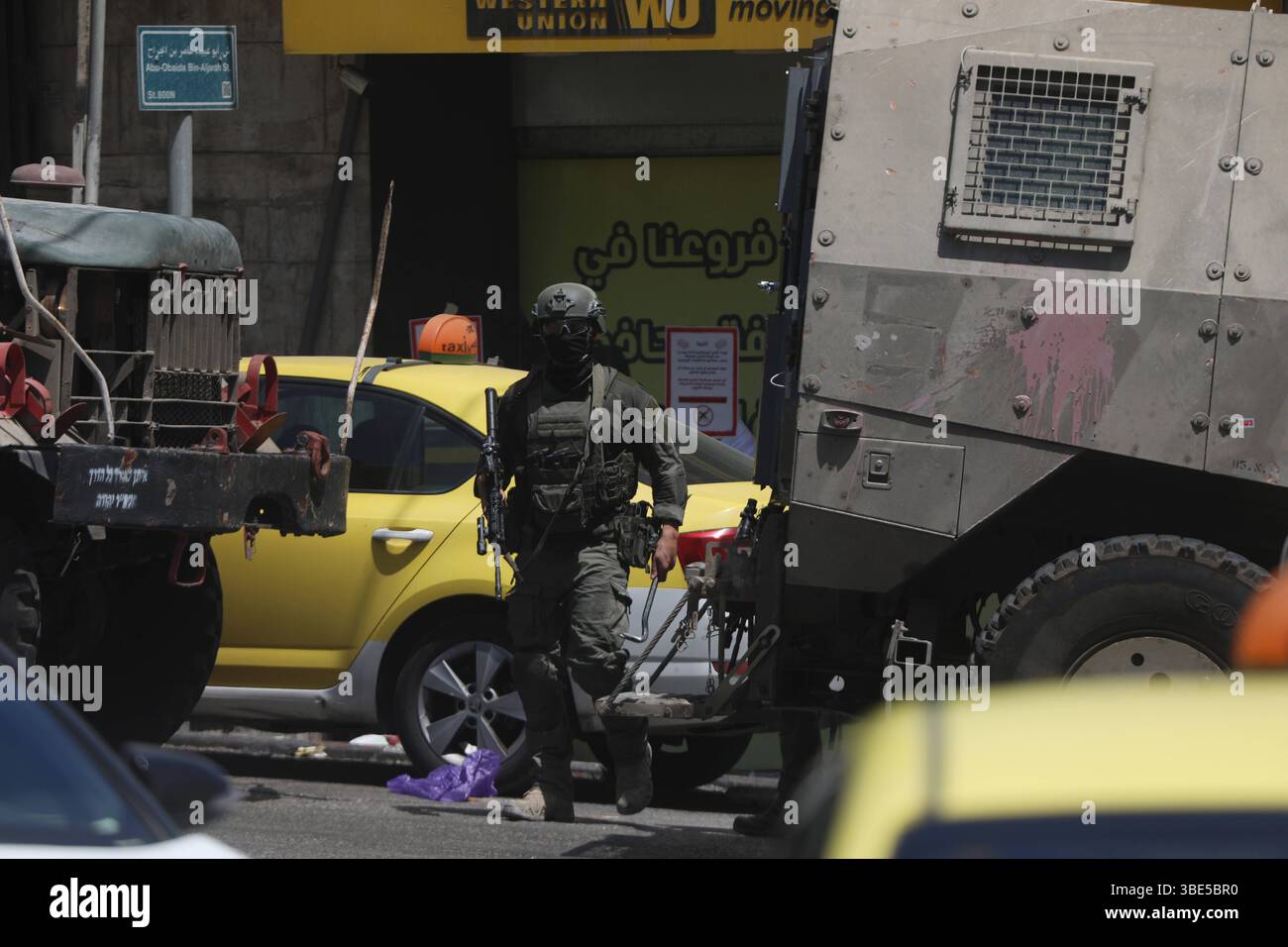 Israeli toops storm a currency exchange shop next to signs warning ...