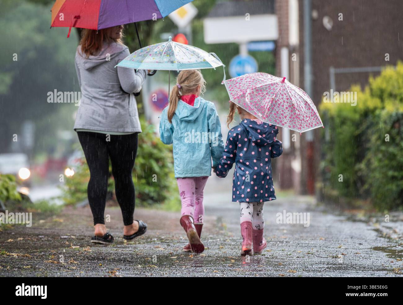 Symbolfoto Regen / Regenschirme / Kinder 2 Kinder laufen Hand in Hand ...