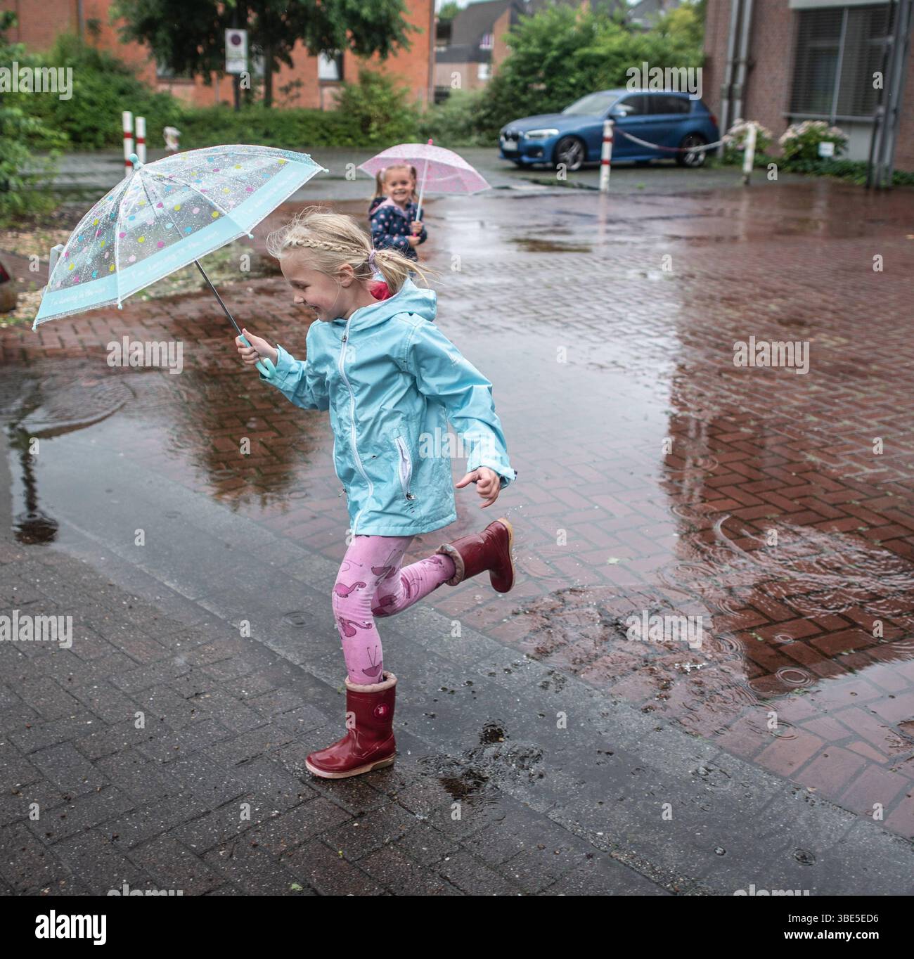 Symbolfoto Regen / Regenschirme / Kinder 2 Kinder laufen Hand in Hand ...