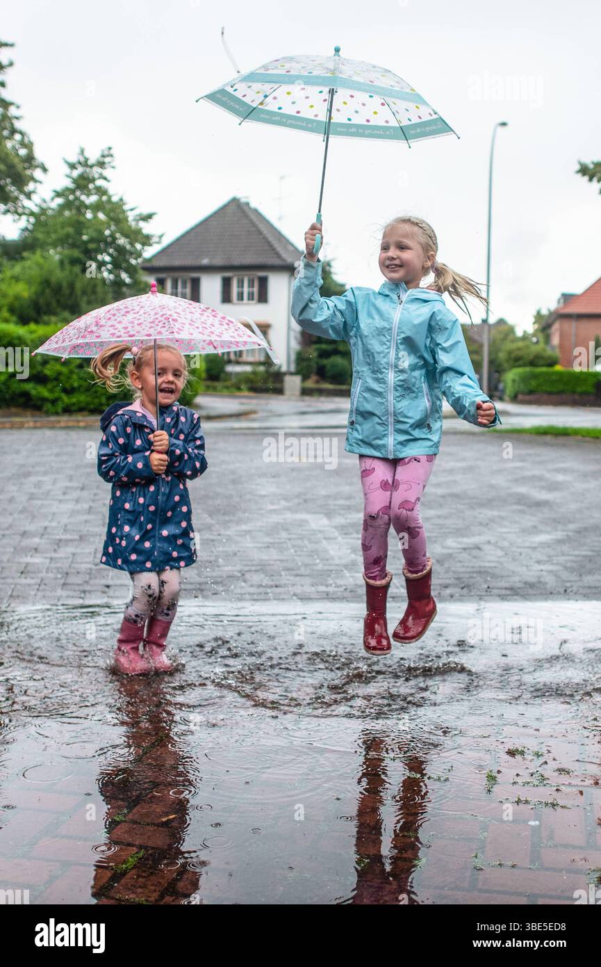Symbolfoto Regen / Regenschirme / Kinder 2 Kinder laufen Hand in Hand ...