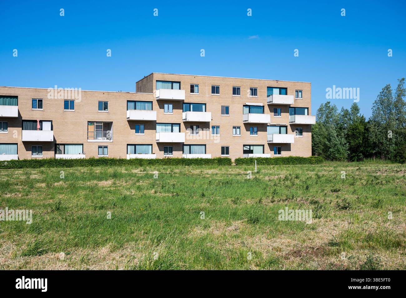 Modest apartment block and green meadow at the borders of the city of ...