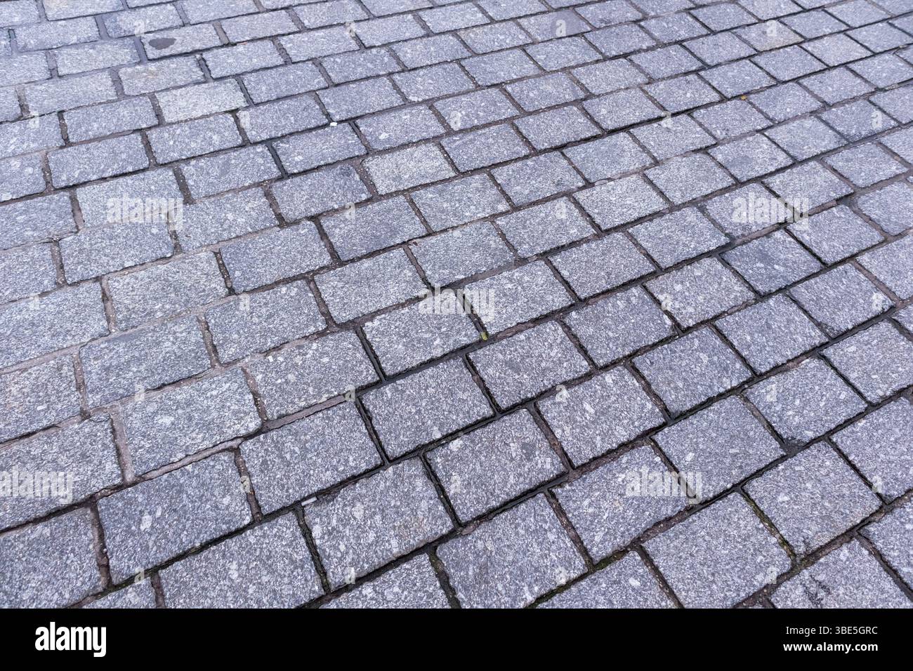 a gray paving stone consisting of rectangular stone blocks arranged in ...