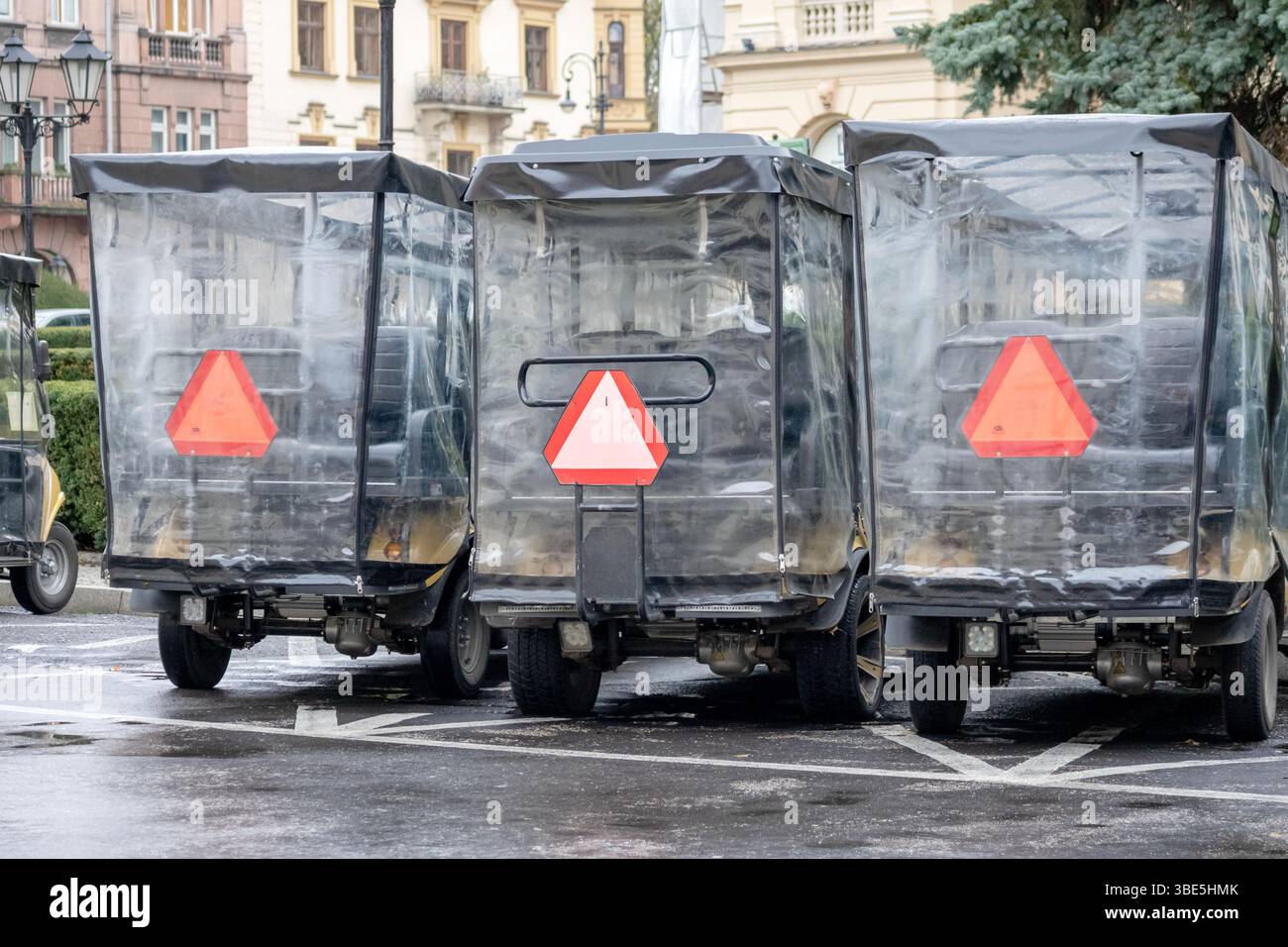 several garbage or cargo carts with orange triangular warning signs on ...