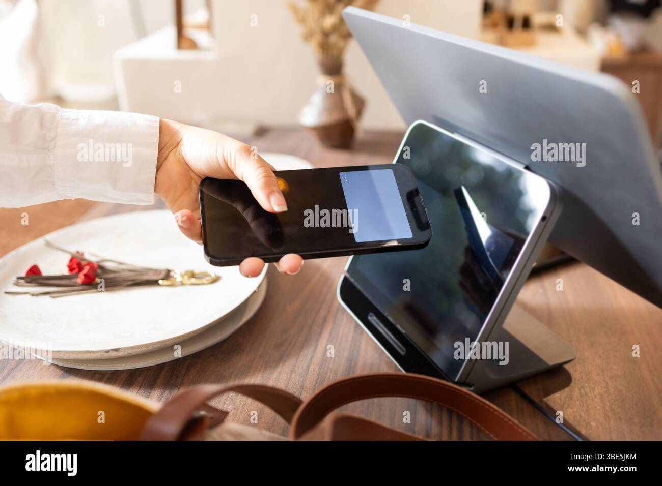 A customer uses a smartphone for a contactless payment at a modern ...