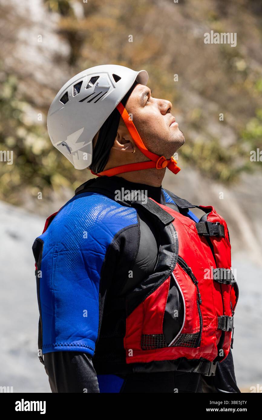 Close-up portrait of a canyoneer wearing a helmet and wetsuit, looking ...