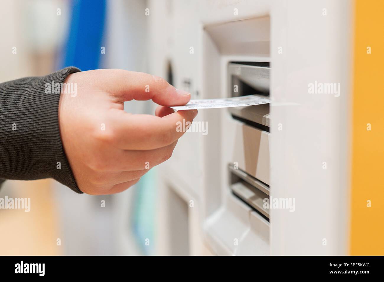 A passenger processes travel documents using an airport check-in kiosk ...