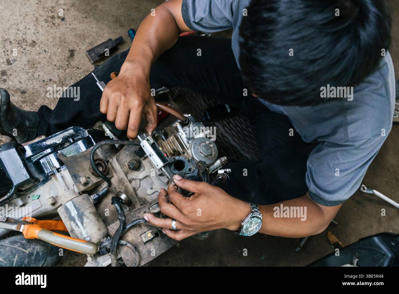 A mechanic carefully repairs a motorcycle engine, demonstrating ...