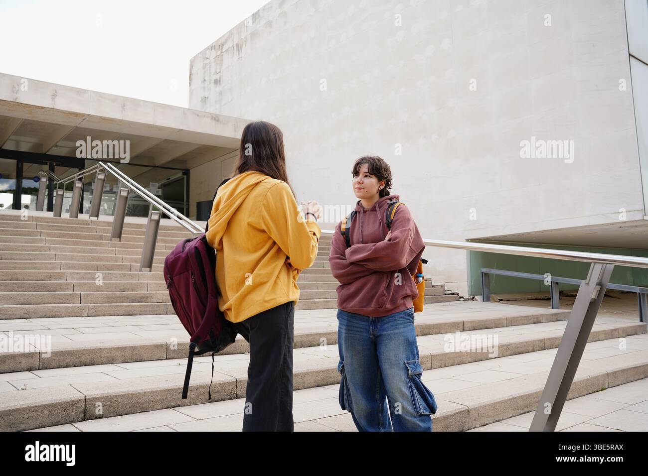 Two teenagers, a non-binary individual and a female, are engaged in a ...