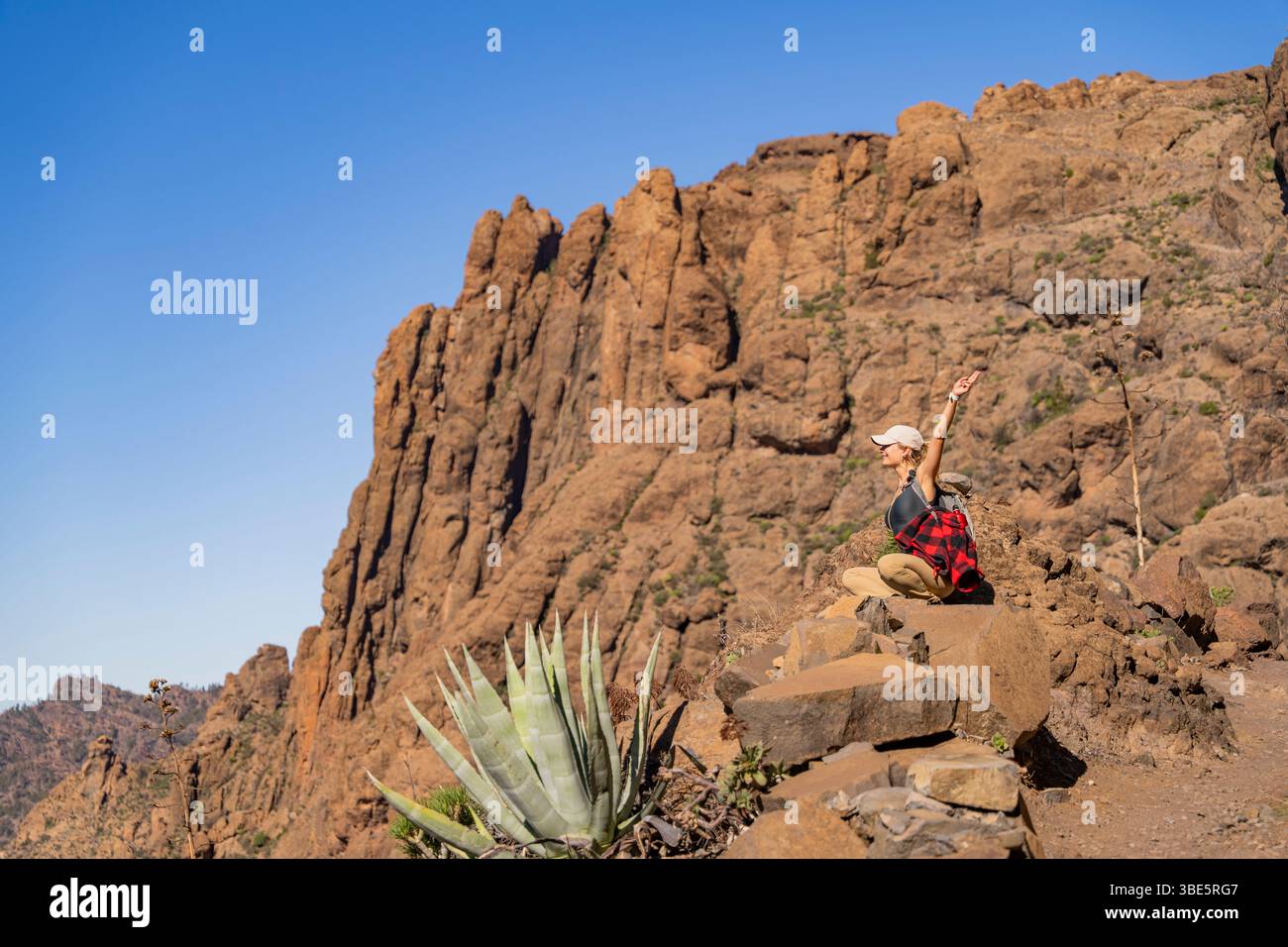 Side view of excited female hiker admiring the rugged terrain of Pico ...