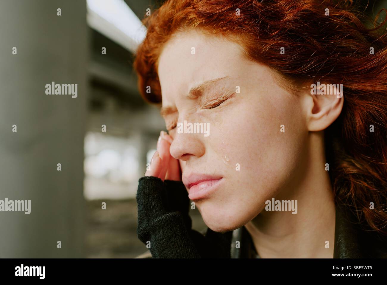 Woman with red hair standing under bridge crying, she feeling lost and ...