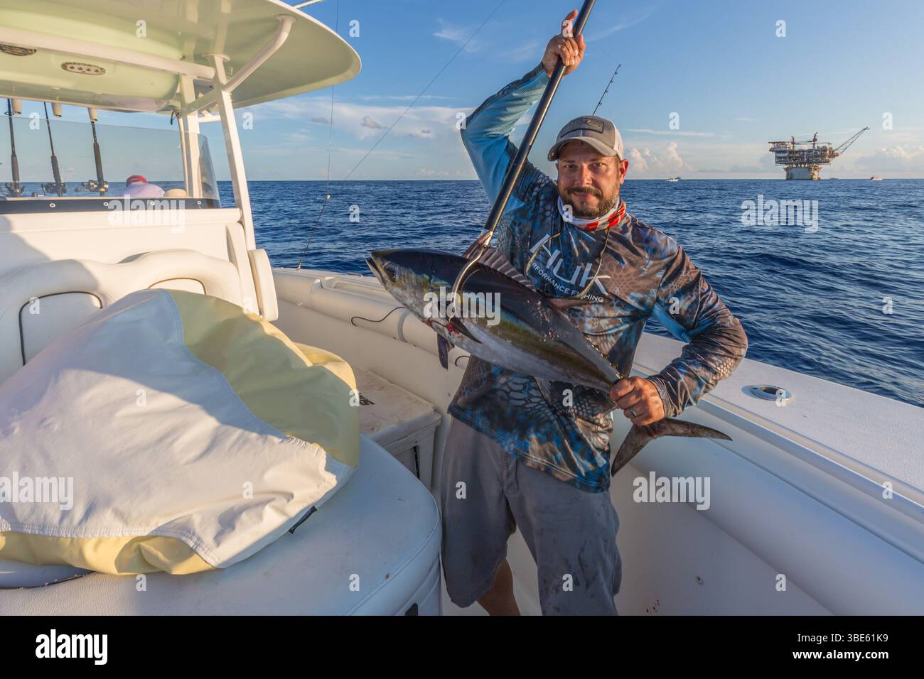 Offshore fisherman showing off his tuna caught near petroleum drilling ...