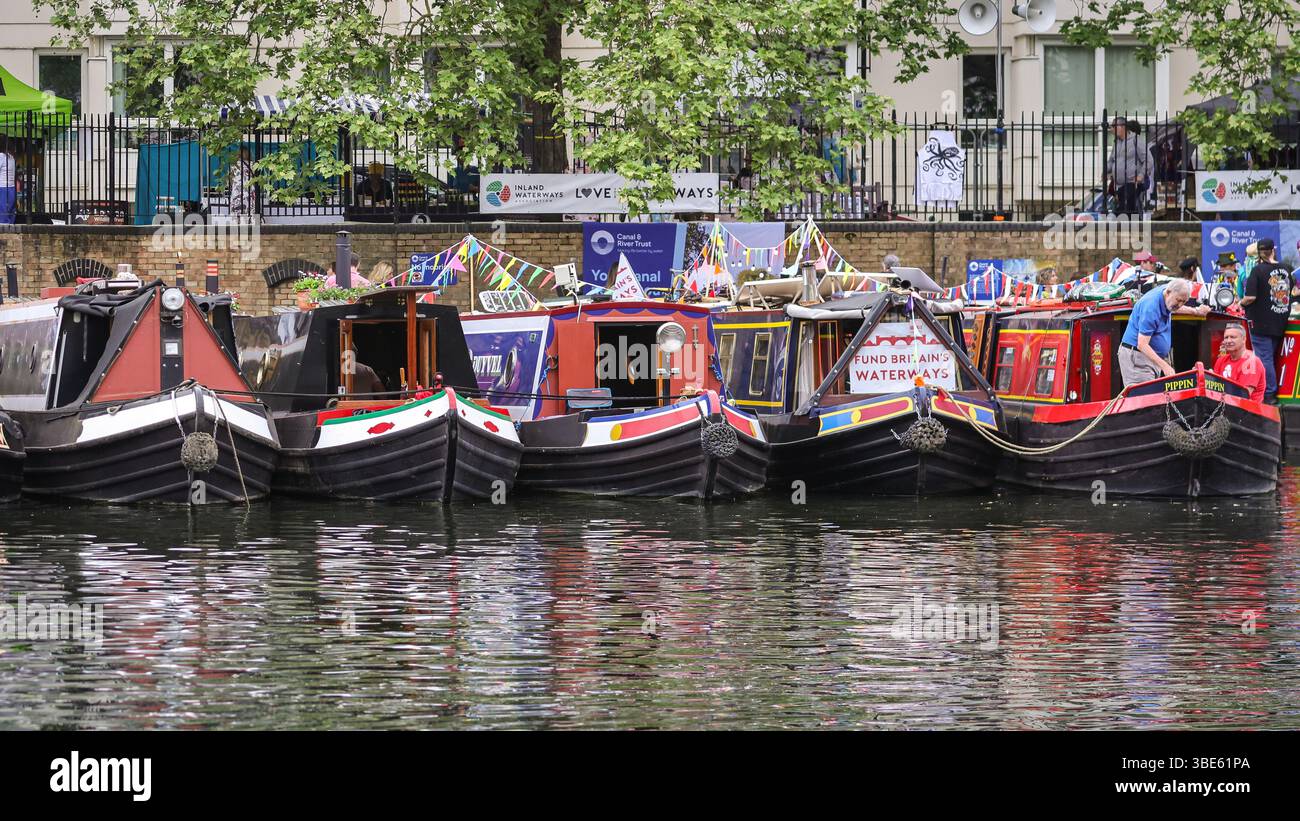 Colourful narrowboats lined up for a canal boat festival at Little ...