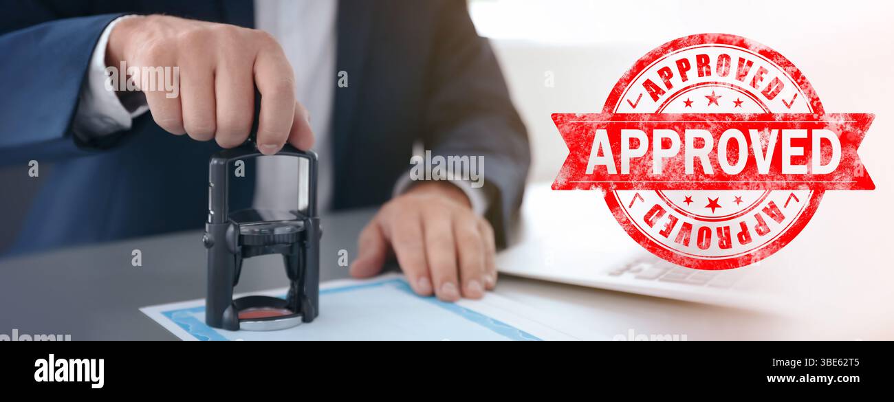 Man stamping document at desk in office and red stamp with word ...