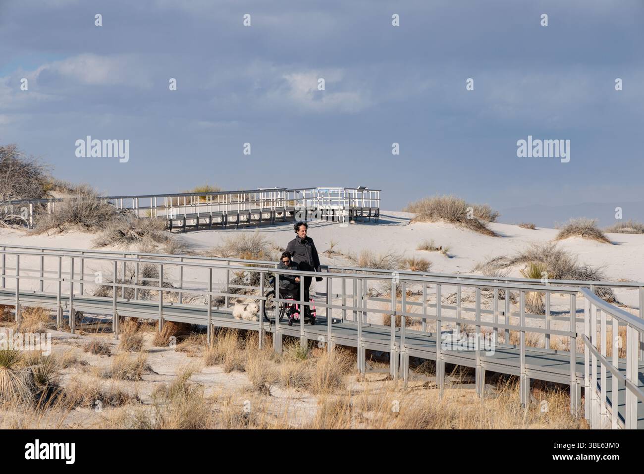 Man and handicapped woman in wheelchair stroll down the Interdune ...