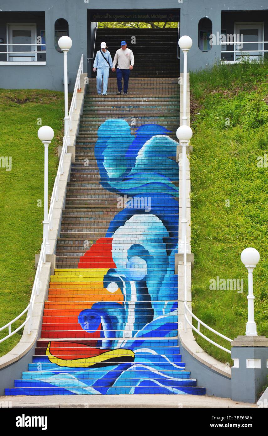 A couple walk along a mural, recently completed by artist Kim Wood ...
