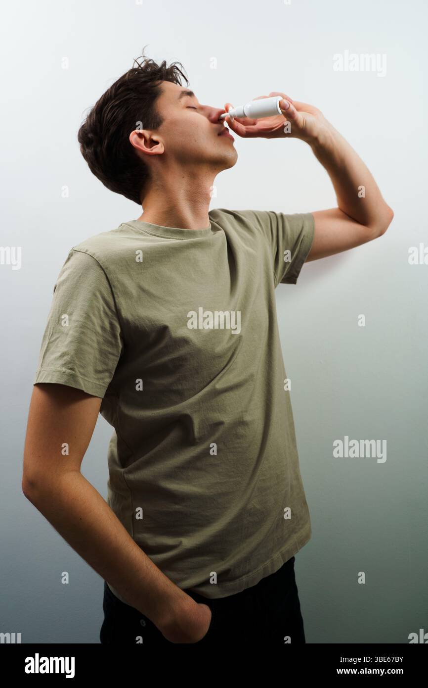 Sick guy injects nose drops for relief from runny nose at home. Man is ...