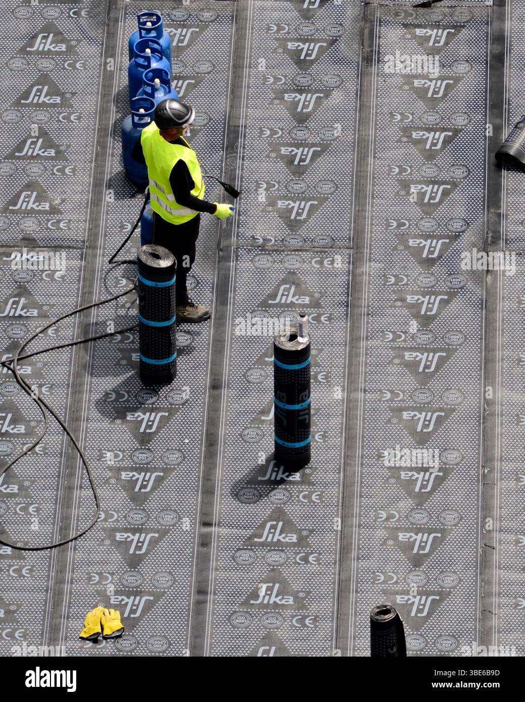 Construction worker using a propane torch to heat and prepare the ...