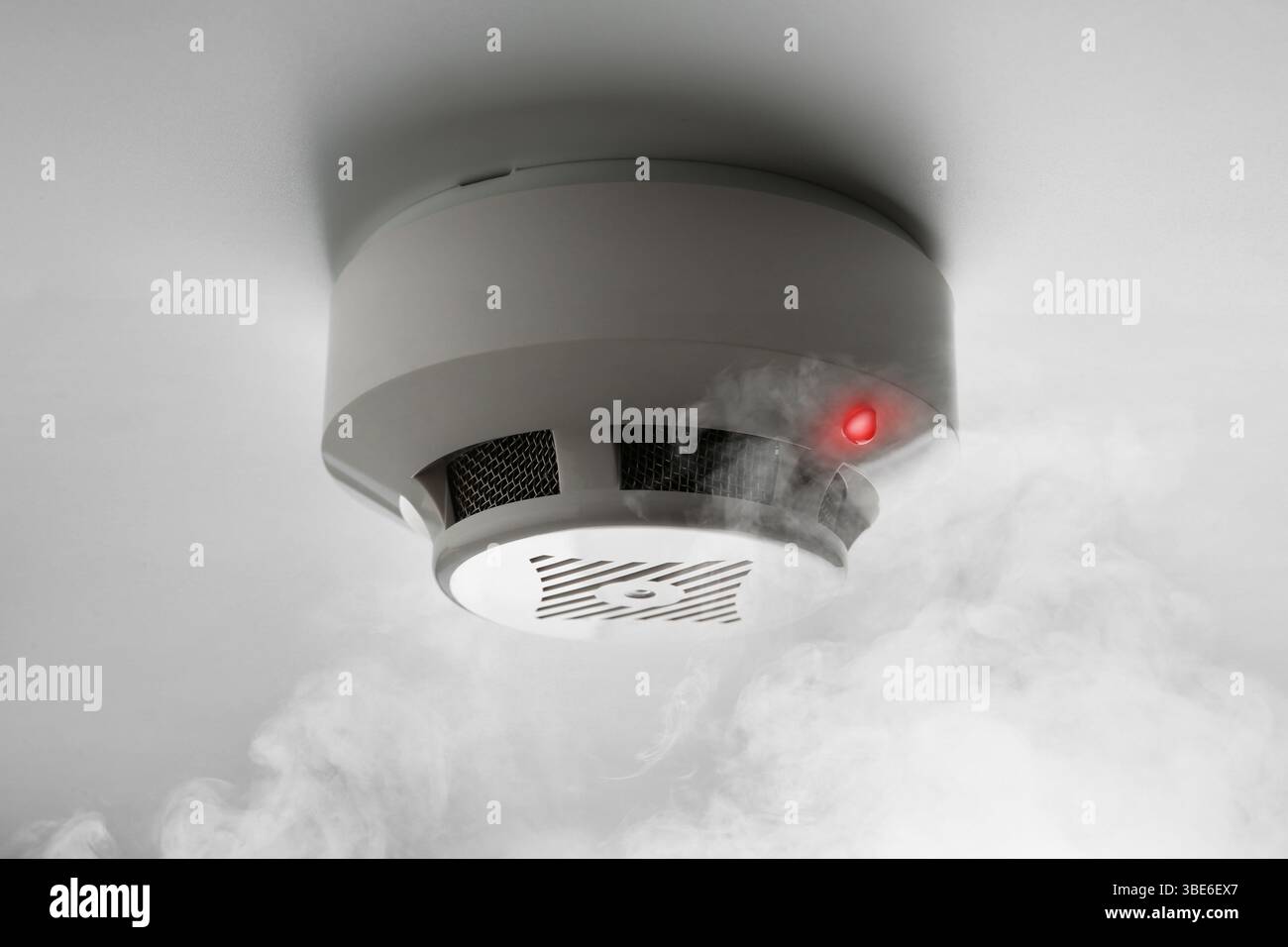 Fire alarm system detector on ceiling triggered by smoke Stock Photo ...
